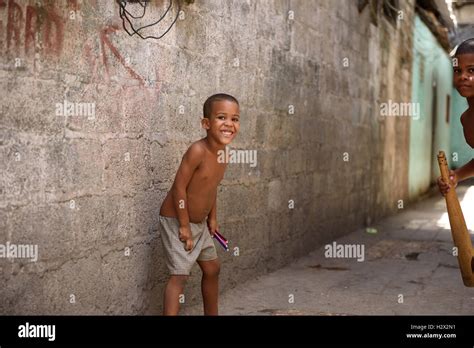 Due Piccoli A Piedi Nudi Ragazzi Sorridenti E In Posa Da Cemento Muro Di Mattoni Della Loro Casa