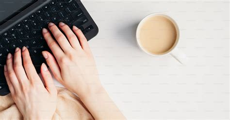 노트북 키보드 평면도에 텍스트를 입력하는 여성 손 담요 커피 컵 노트북이 있는 현대적인 미니멀한 여성 작업 공간 사진 Unsplash의 컵 이미지