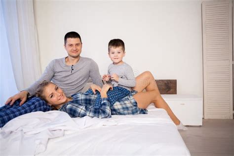 Mom Dad And Son In The Morning Lying On The Bed At Home In A Good Mood Stock Image Image Of