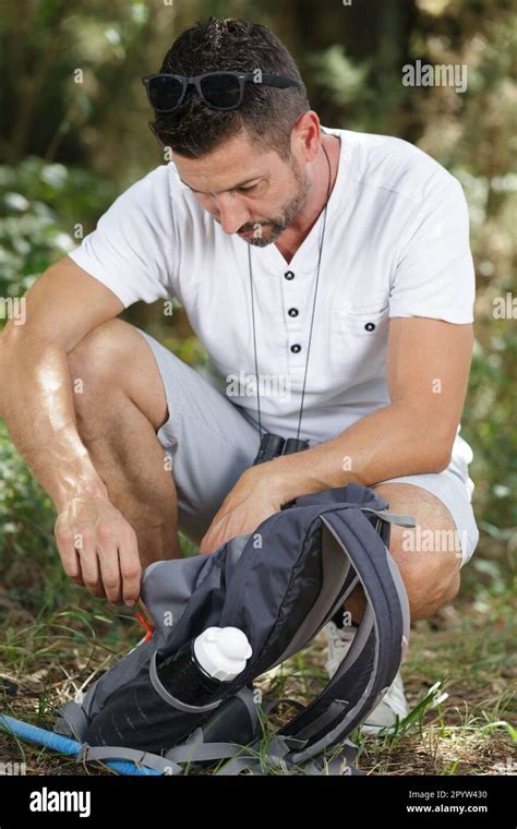 Hiker Searching Something On His Backpack Stock Photo Alamy