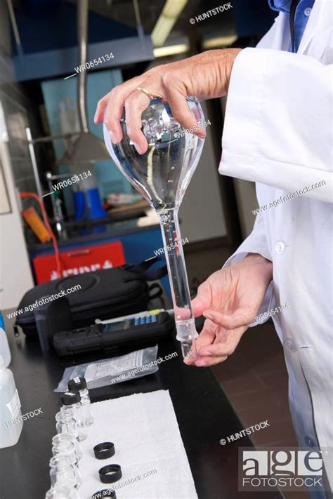 Scientist Mixing Liquid Contents Of Flask By Inverting Flask In The Laboratory Of Water