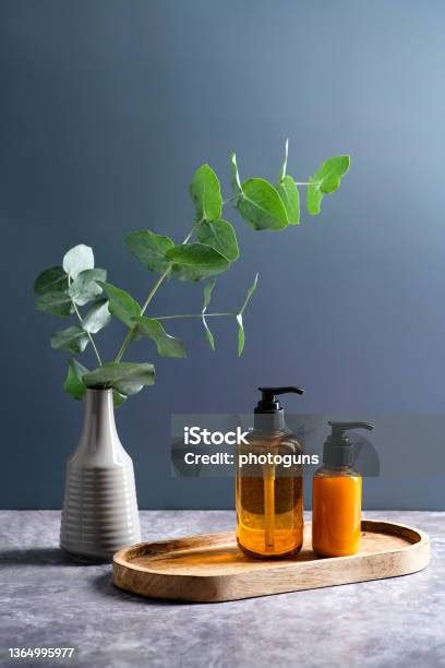 짙은 파란색 배경에 유칼립투스 식물이 있는 호박색 유리 디스펜서 병과 화병 천연 유기농 Spa 화장품 세트 샴푸와 샤워 젤용기 0명에 대한 스톡 사진 및 기타 이미지