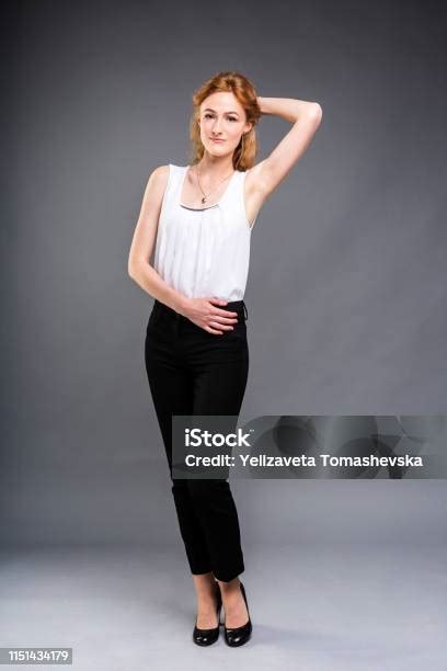 하이힐 검은 바지와 흰색 셔츠에 긴 빨간 머리를 가진 아름다운 젊은 백인 여성은 회색 고립 된 배경에 전체 성장에 서있다 경영자에 대한 스톡 사진 및 기타 이미지 Istock