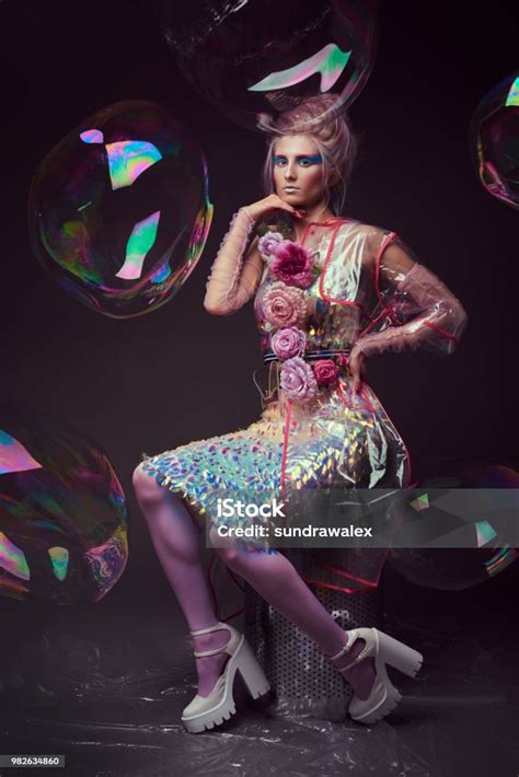 Biofuture 퐁파두르 스타일에 화려한 여자입니다 화려한 메이크업과 헤어스타일 비누 거품을 통해 Photoshoot 패션 투명 비옷에 여성 개인 장식품에 대한 스톡 사진