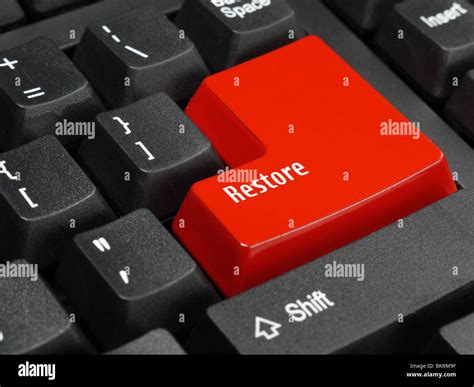closeup of computer keyboard key in red color spelling restore stock