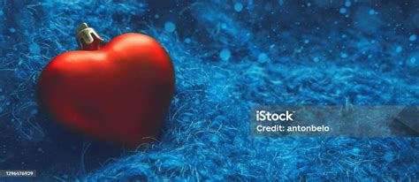 축제 겨울 컨셉 배너 보케와 멋진 파란색 배경에 빨간 하트 모양의 크리스마스 트리 장난감 새해 크리스마스 또는 발렌타인 데이 배경 공간을 복사합니다 모션블러에 대한 스톡