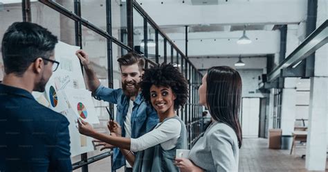 스마트 캐주얼웨어 계획 사업 전략에 젊은 현대인들의 전체 길이 젊은 여자가 사무실의 유리 벽에 표시된 큰 종이를 가리키는 동안 사진 Unsplash의 사업 이미지