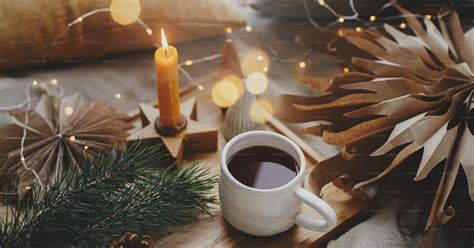 스칸디나비아 방에서 크리스마스 별 황금빛 조명 소나무 촛불 베개가 있는 부드러운 침대에서 따뜻한 차 한 잔 아늑한 숙소 분위기 있는 마법의 순간 휘게 겨울 방학