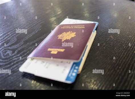 Partially Burred French Passport On Table With Plane Boarding Pass