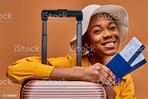 흰 모자를 쓴 한 여성이 가방에 기대어 있는 파란색 여권을 손에 들고 두 장의 티켓을 들고 있다 여행 컨셉 관광객에 대한 스톡 사진 및 기타 이미지 Istock