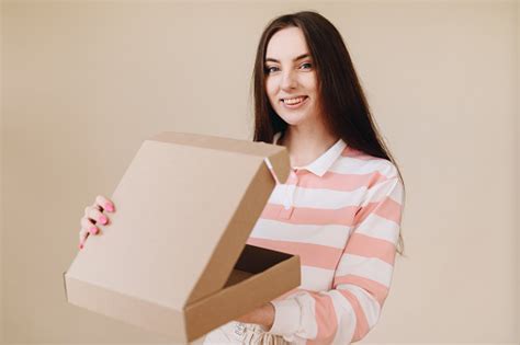 젊은 여성의 손에 든 평평한 사각형 상자 베이지 색 배경에 손에 소포를 들고 웃고있는 소녀 백인종에 대한 스톡 사진 및 기타 이미지 Istock