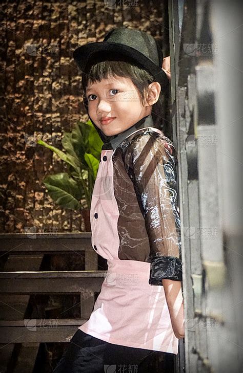 一个印度尼西亚男孩坐在自家门前的台阶上