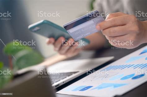 온라인 쇼핑을 위해 스마트 폰에 신용 카드 타이핑 메시지를 들고있는 여성 손의 클로즈업 샷 Brand Name Online Messaging Platform에 대한 스톡