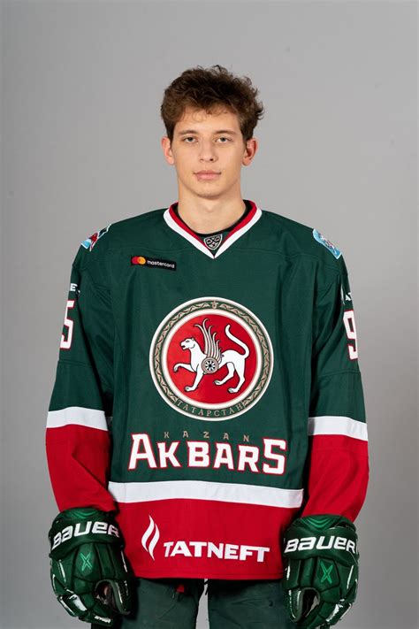 a young man in a hockey uniform posing for the camera with his hands on ...