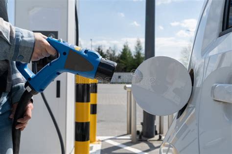 Woman Holding Ccs Fast Charging Socket Type Plug For Electric Vehicles At Ev Car Charging