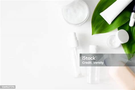 흰색 스퀴즈 튜브 크림 병 드롭퍼 유리 세럼 비누 녹색 열대 잎이있는 연속자는 흰색 배경 상단 보기 복사 공간에 평평하게 놓여 있습니다 뷰티 스킨케어 천연 화장품 스톡 사진