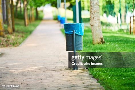 Pathway In An Empty Park With Garbage Cans On The Sides In Summer High