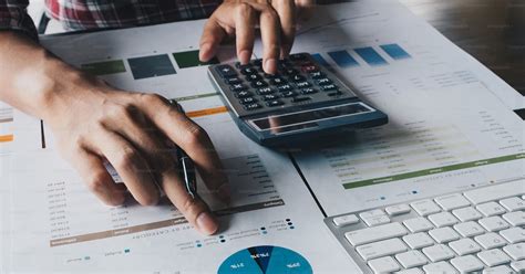 재무 문서에서 숫자를 계산하기 위해 계산기를 사용하여 책상 사무실에서 일하는 남자 재무 회계 개념 사진 Unsplash의 계산기 이미지