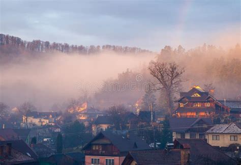 Foggy Small Village Enveloped By Mist And Surrounded By Lush Trees In