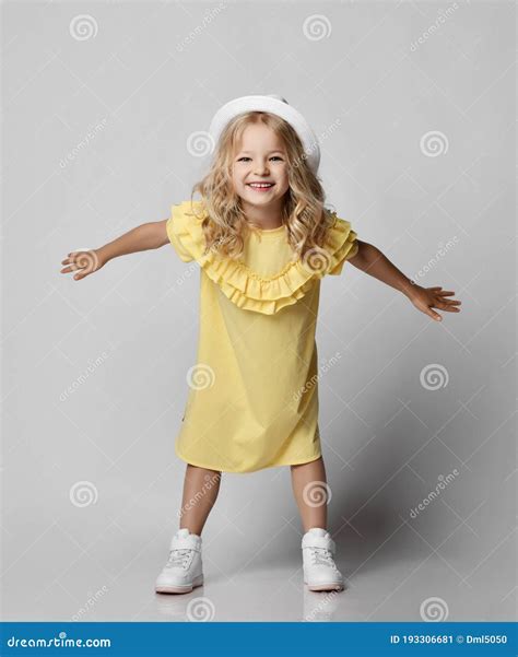 Jovencita Rubia Rubia Rubia Rebelde Con Sombrero Blanco Vestido Amarillo Y Zapatillas De Deporte