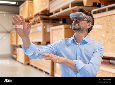 Mature Businessman Wearing Virtual Reality Simulators At Warehouse