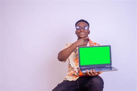 Premium Photo Excited Black Teen Guy Holding Laptop Computer With Empty Black Screen