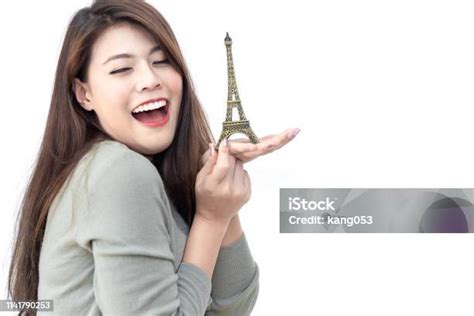 행복 아름 다운 젊은 아시아 여자 들고 금속 작은 에펠 타워 모델 흰색 배경에 고립 된 손에 꿈의 여행자 랜드 마크 세계의 개념