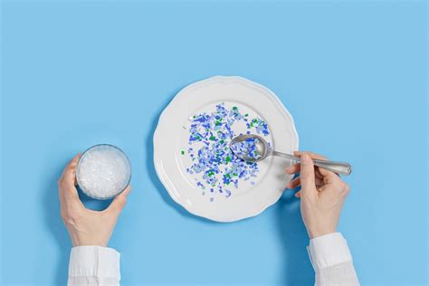 Plate With Plastic Pieces Instead Of Food And Glass Of Microplastics