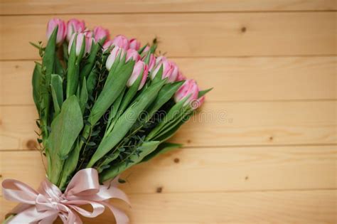 Bouquet Of Bright Pink Tulips With A Beautiful Bow On A Wooden