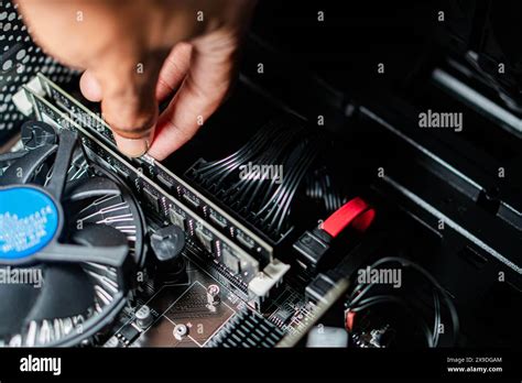 close up of a person installing ram into a computer motherboard the