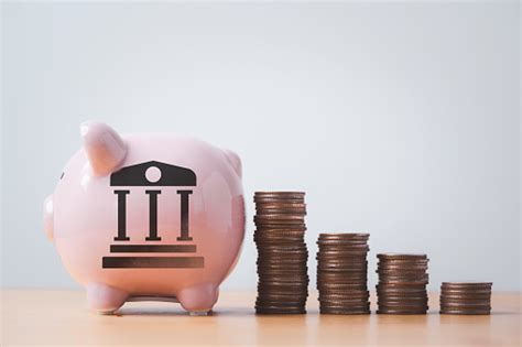 테이블에 쌓이는 동전이 감소하는 분홍색 돼지 저금통 이익과 배당 개념을 얻기 위한 투자를 위한 돈 절약 및 예금 0명에 대한