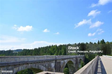 두 개의 큰 벽돌 및 콘크리트 철도 교량 그들 및 몇몇 백색 푹신한 구름 표시 폴란드 주위 여행 중 하나 동안 본 여름 하늘에 나무 꼭대기에서 본 0명에 대한 스톡 사진 및