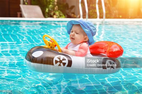 아기는 수영을 좋아합니다 바다에서 여름 방학 1 세 미만의 어린 소녀가 자동차 모양으로 팽창 식 보트를 운전 하 고 있습니다