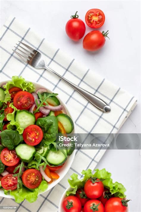 회색 대리석 배경에 흰색 접시에 야채 맨 위 보기입니다 체리 토마토 오이 아루굴라 바질 올리브 오일로 만든 샐러드 건강한 음식 개념 채식주의 식단 개념에 대한 스톡 사진 및