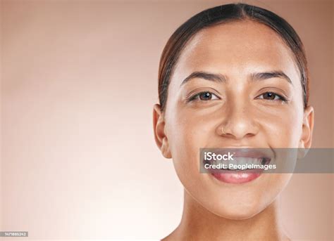 건강한 치아와 매력적인 미소로 마케팅하는 자연스러운 여성의 아름다움 초상화 및 스킨케어 화장품 광고를 위한 베이지색 스튜디오 모형 배경에 아름다운 얼굴을 가진 웰빙 모델