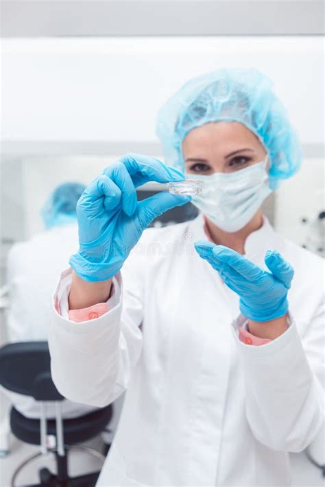 Woman Scientist Showing Her Newest Biotech Experiment In Lab Stock