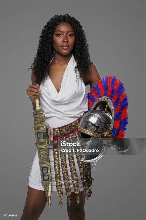 아프리카계 미국인 여성은 화려한 벨트 홀드 헬멧과 함께 로마 스타일의 가운을 입는다 검투사에 대한 스톡 사진 및 기타 이미지 검투사 의류 Empire Istock