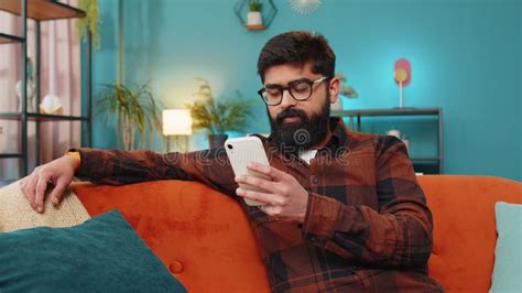 Shocked Sad Indian Young Man Using Smartphone Reading Negative Message