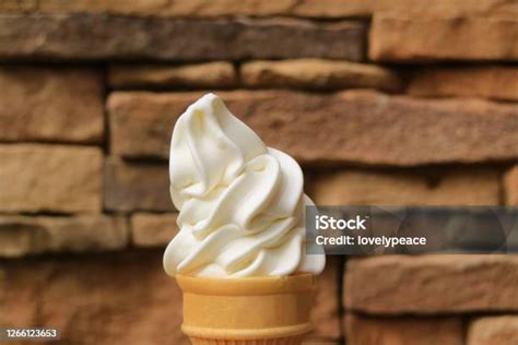 블러리 브라운 스톤 블록 벽에 대한 군침이 도는 바닐라 소프트 서브 아이스크림 콘 기계 아이스크림에 대한 스톡 사진 및 기타 이미지 기계 아이스크림 바닐라 아이스크림