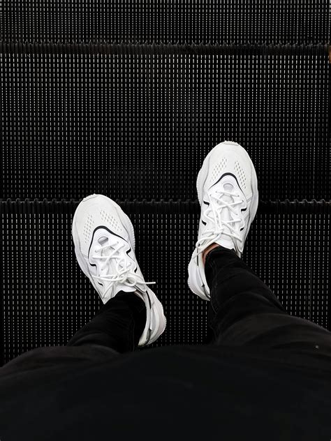 가죽 검은 색 바지 검은 색 운동화 뒷모습 문신 벽돌 벽 숫자 신발 의자 쿠션 확대에 관한 무료 스톡 사진