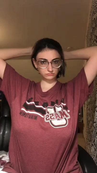 A Woman Sitting In A Chair With Her Hands Behind Her Head And Wearing