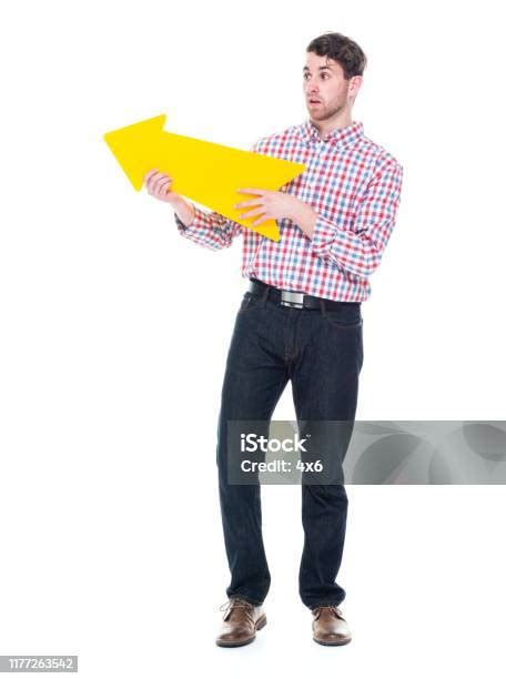 전체 길이 1 인 전면 2029 세 성인 잘 생긴 사람들 백인 젊은 남자 남성 앞에 서 흰색 배경 착용 깅감 청바지 는 미소 행복 쾌활 하 고 들고 화살표 기호 20 29