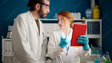Man And Woman Wearing Sciencist Uniform Using Touchpad At Laboratory