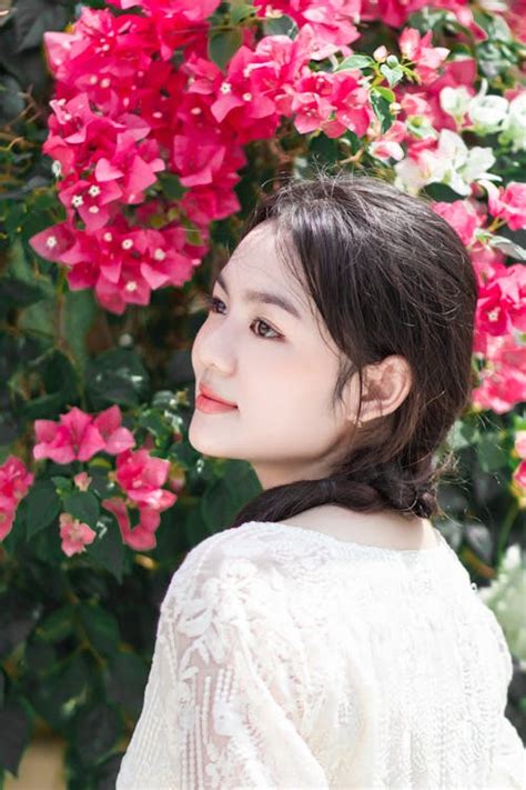 갈색 머리 고요한 긍정적인 기쁨 꽃 꽃 배경 녹지 따뜻함 레저 매력적인 모델 미소 짓는 밝은 날