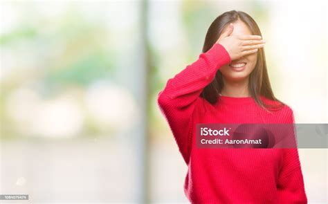 젊은 아시아 여자는 웃 고 놀람에 대 한 눈을 덮고 얼굴에 손으로 고립 된 배경 위에 겨울 스웨터를 입고 눈 먼 개념입니다 가리기에 대한 스톡 사진 및 기타 이미지 Istock