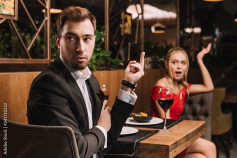 Selective Focus Of Offended Man Showing Middle Finger To Shocked