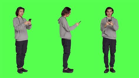 Adult Texting Messages On Phone Standing Over Greenscreen Background Using Social Media App To
