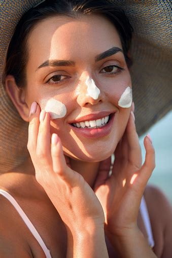 얼굴에 선크림을 바르는 여자 미소 스킨케어 컨셉 바디 자외선 차단 선스크린 모자를 쓴 여성이 피부에 보습 로션을 바르십시오 30 34세에 대한 스톡 사진 및 기타 이미지
