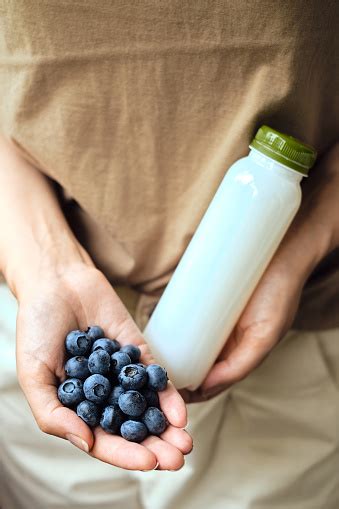 블루베리와 여자의 손에 요구르트 한 병 천연 유기농 베리 신선한 블루베리가 닫힙습니다 맛있는 여름 베리 적절한 영양 디저트에 대한 베리 건강한 라이프스타일 건강한 생활방식에