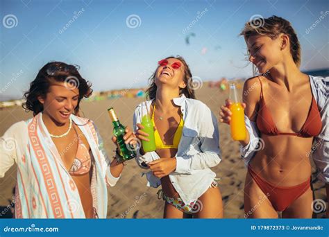 Three Beautiful Attractive Young Women Having Fun On The Beach Stock